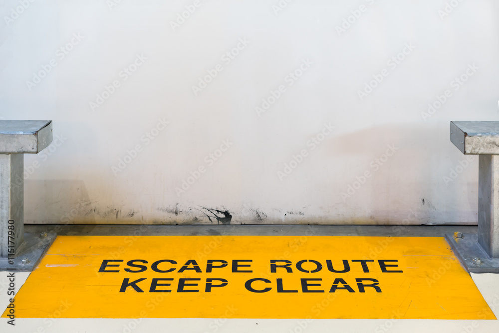 Escape route, keep clear sign blocked by concrete wall with copy space ...