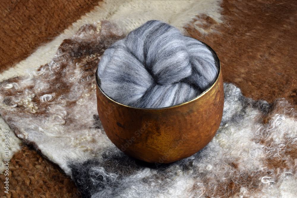 Gray variegated Merino sheep wool fiber in a copper glass bowl on top ...