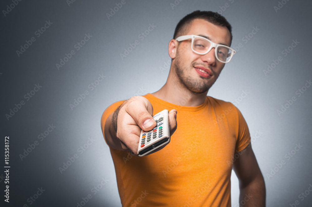 Man with remote control isolated on dark gray background. Guy holding ...