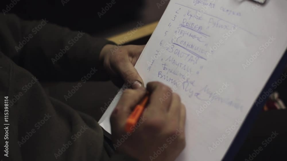 Man sitting on chair and underline words in list on sheet of paper in ...