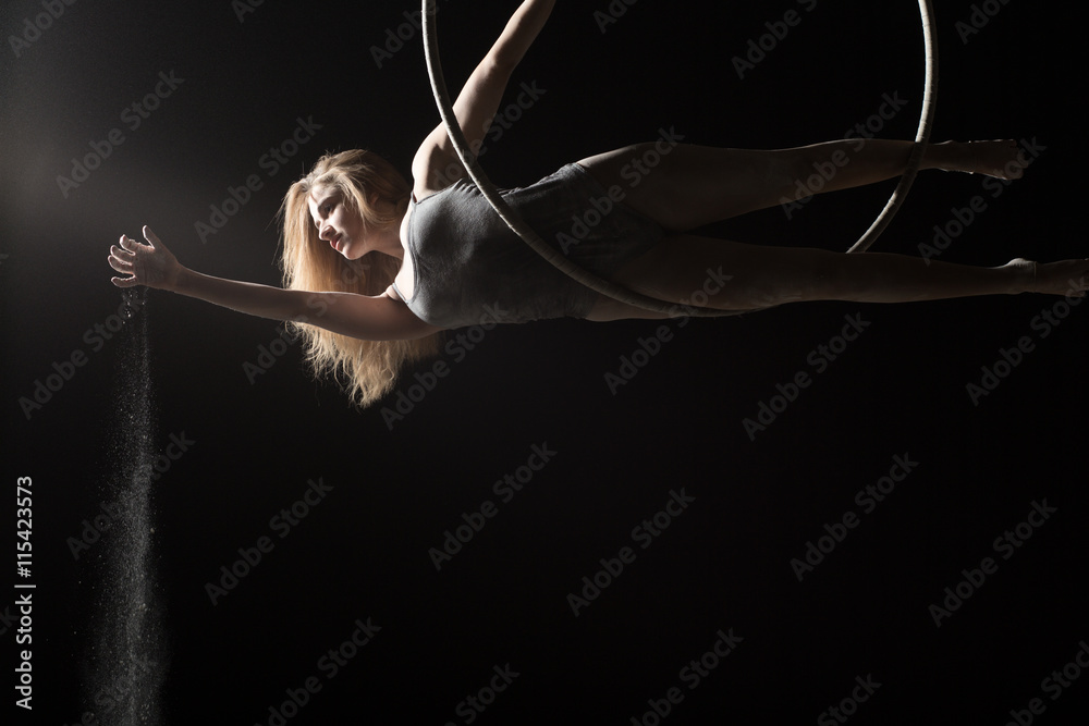Acrobatic woman hunging on aerial hoop and pouring flour Stock Photo ...