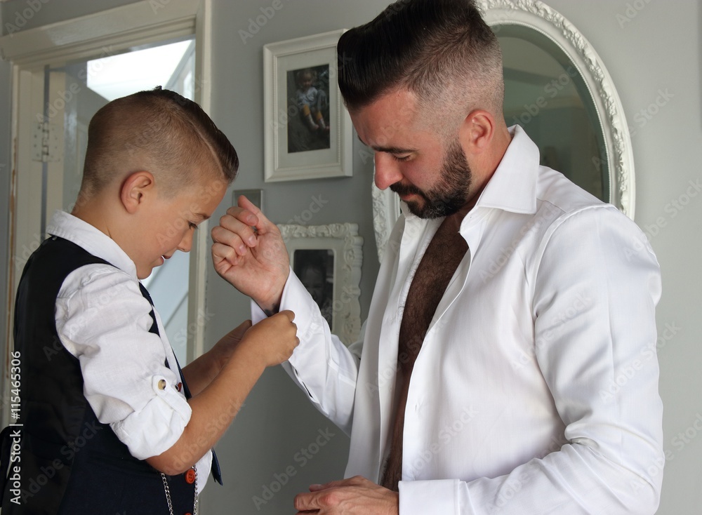A young boy dressing his father on his wedding day as part of his best ...