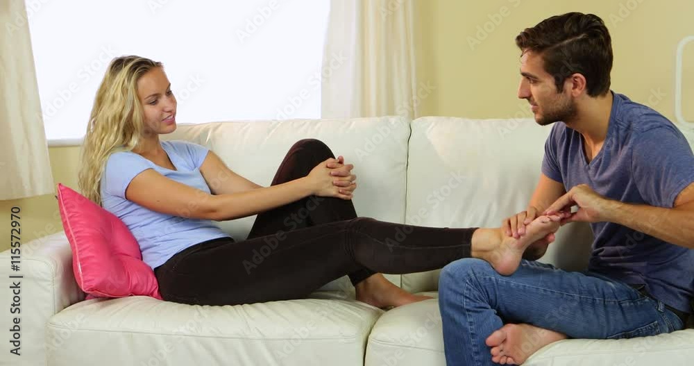 Caring boyfriend giving his blonde girlfriend a foot rub Stock Video ...