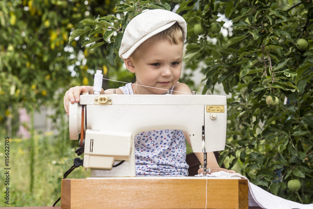 boy at the sewing machine sews in nature Stock Photo | Adobe Stock