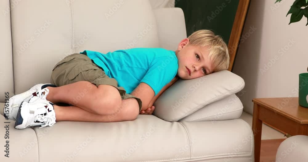 Sad little boy lying on the couch Stock Video | Adobe Stock