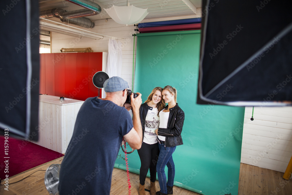 Rear view of photographer photographing fashion models in studio Stock ...