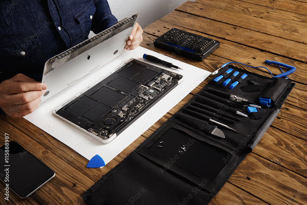 Service man opens backside topcase cover of computer laptop before ...