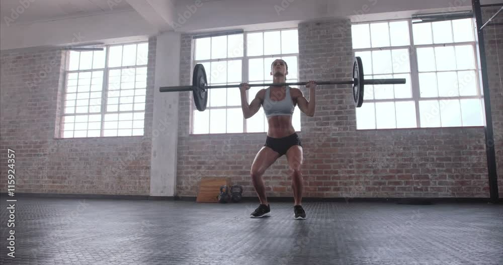 Female bodybuilder doing exercise with heavy weight bar. Full length of ...