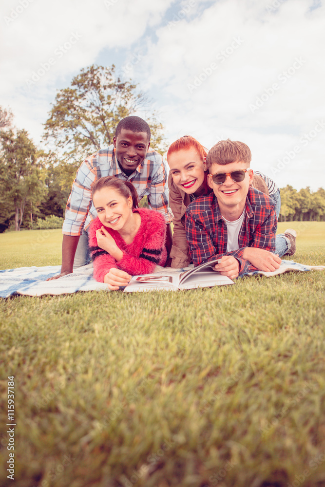 Image of happy best friends lying on picnic rug and smiling for camera ...