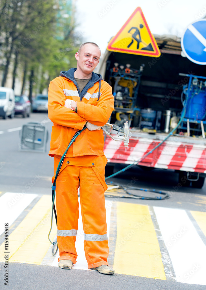 Smiling road construction worker on city street during zebra crossing ...