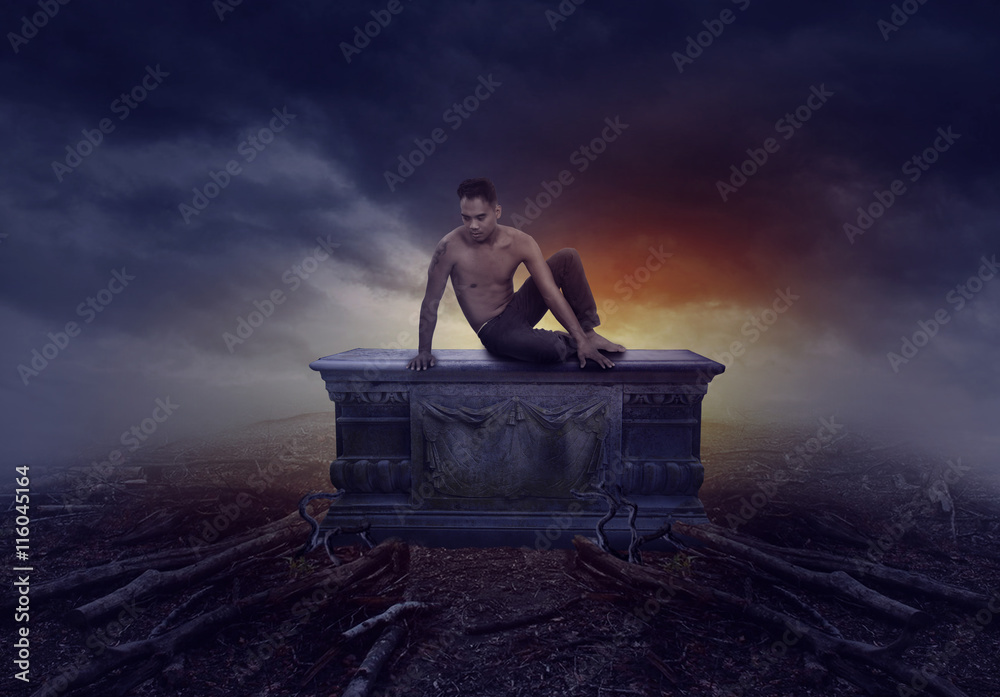 young man sitting on a grave Stock Photo | Adobe Stock