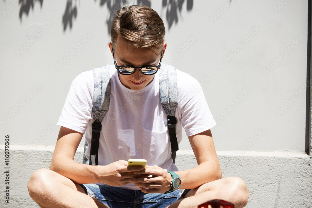 Handsome Caucasian 15-year old boy wearing backpack sitting on the ...