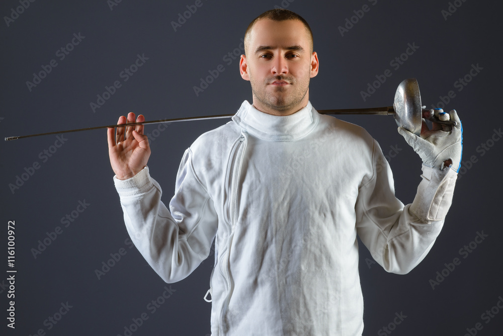 Fencing athlete posing with a sword or epee on gray background Stock ...