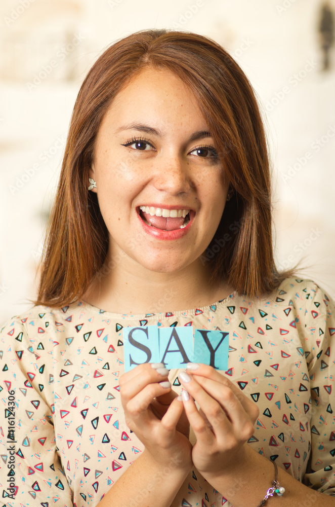 Headshot charming brunette woman holding up small letters spelling the ...