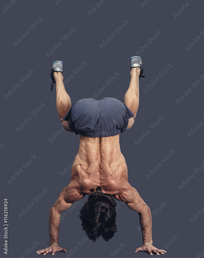 Sporty shirtless male upside down. Isolated on a grey background. Stock ...