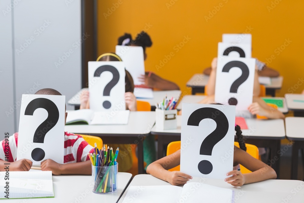School kids covering their face with question mark sign Stock Photo ...