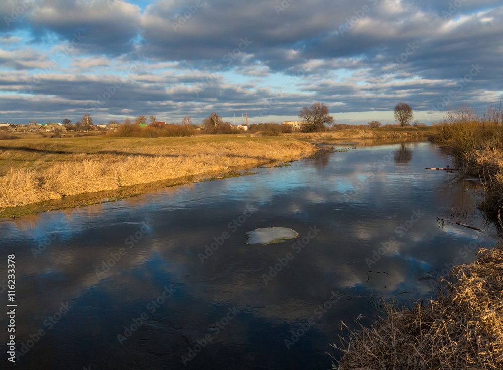 Thaw and melting ice on a small river in the outback of Belarus. Rural ...