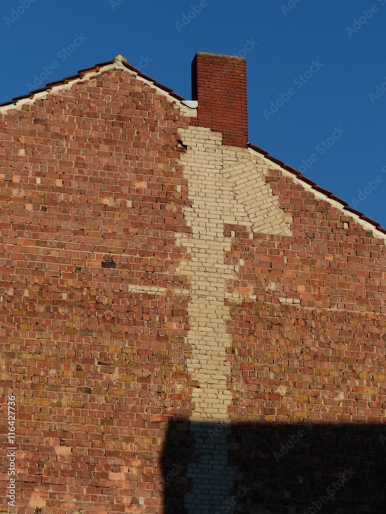 Altes Mauerwerk aus rotem Backstein einer Fassade mit spitzem Giebel ...