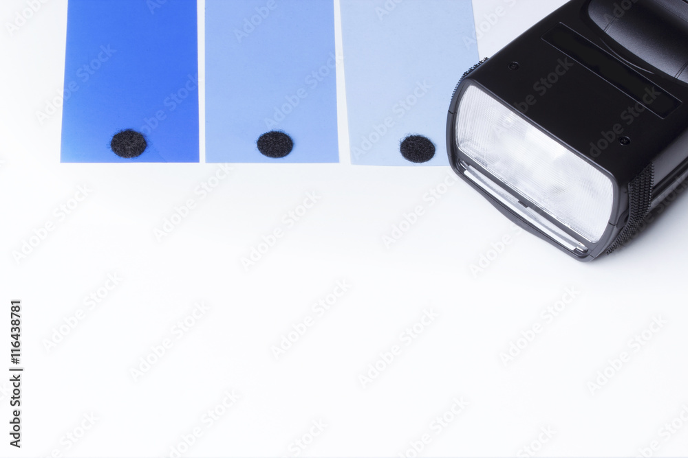 Head of a camera flash, over a white background with the blue gels for ...