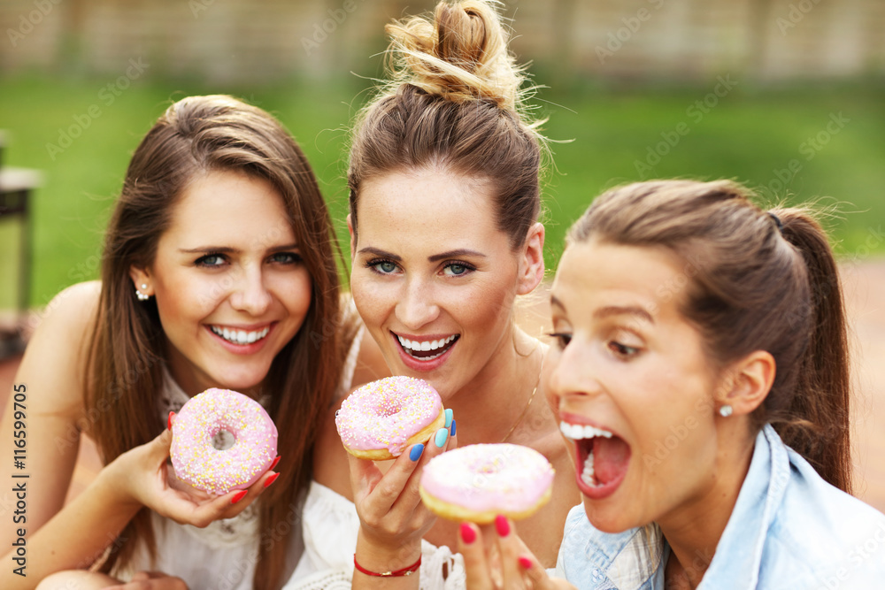 Happy group of friends eating donuts outdoors Stock Photo | Adobe Stock