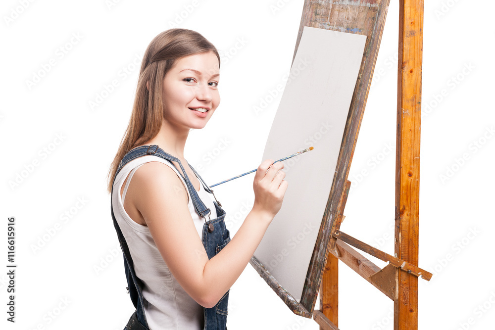 Young smiling woman painter with paintbrush standing at easel Stock ...