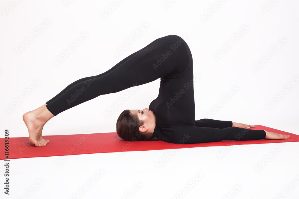 Beautiful athletic girl in black suit doing yoga. halasana asana - plow ...