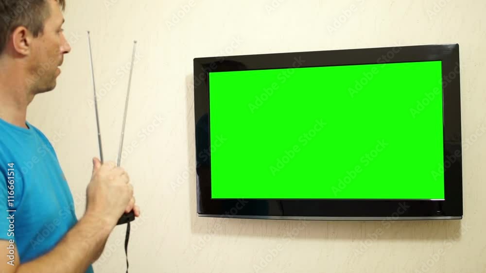 Male holding and adjusting a rabbit ears type of antenna to adjust ...