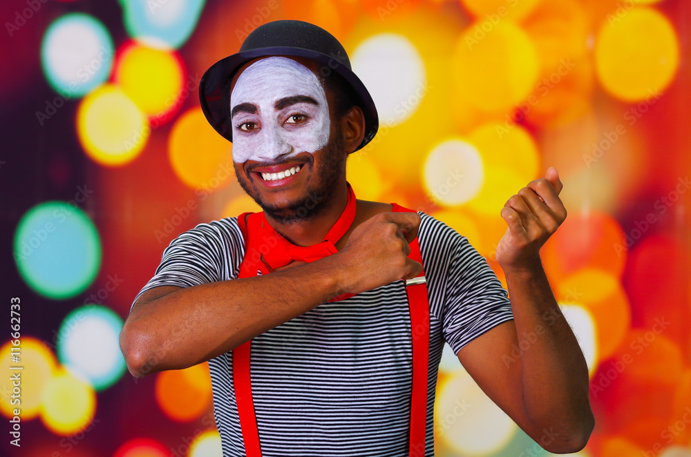 Pantomime man wearing facial paint posing for camera, using hands ...