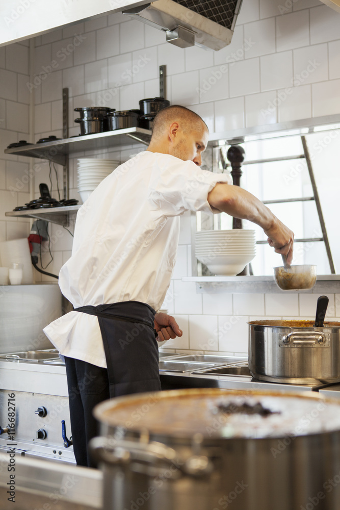 Rear view of chef preparing food in commercial kitchen Stock Photo ...