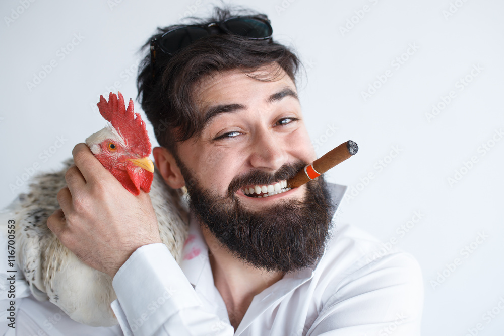Handsome man holding a chicken. Stock Photo | Adobe Stock