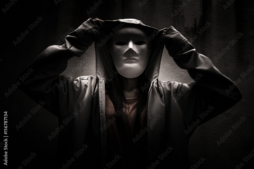A stranger woman wearing hoodie with white mask hiding in the dark ...