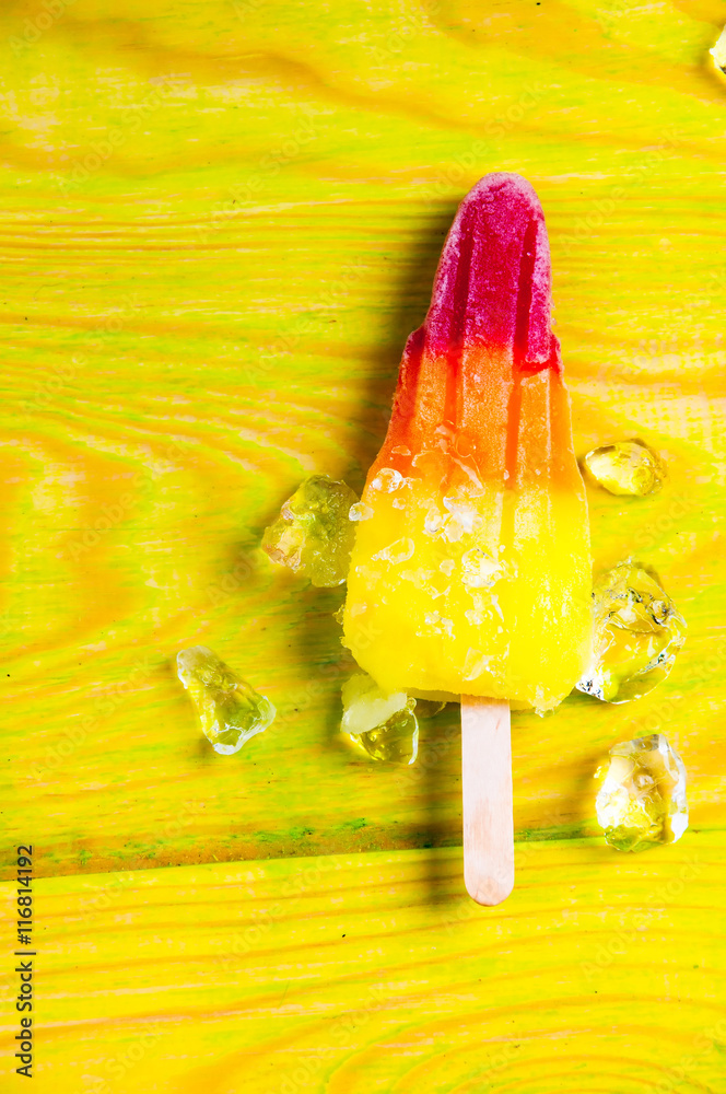 Colorful ice lolly on green wooden background Stock Photo | Adobe Stock