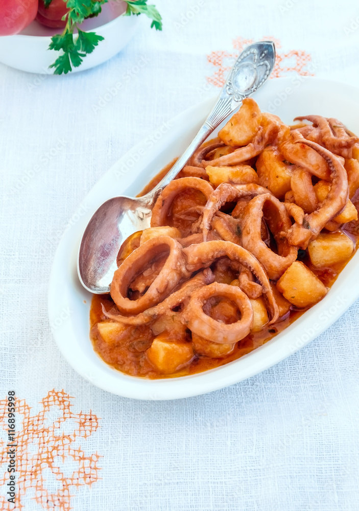 Fish Stew. Stewed squid rings (calamari) in tomato sauce with potatoes ...