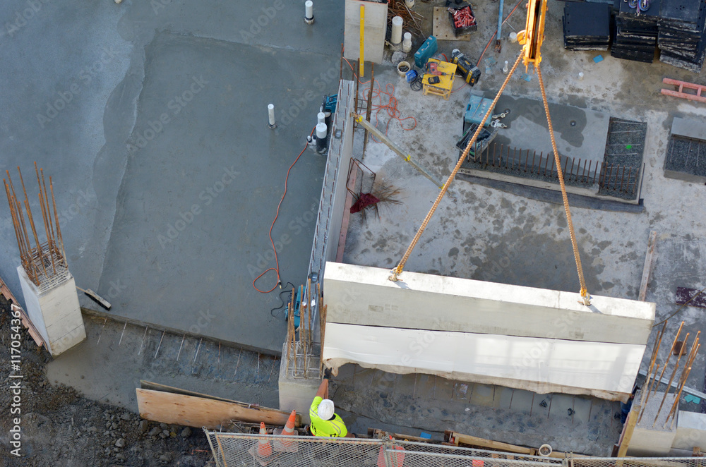 Construction workers guides a structural precast concrete into p Stock ...