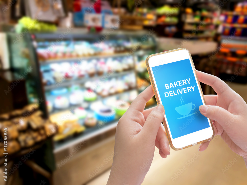 Hand holding mobile phone with Bakery delivery word with blur bakery ...