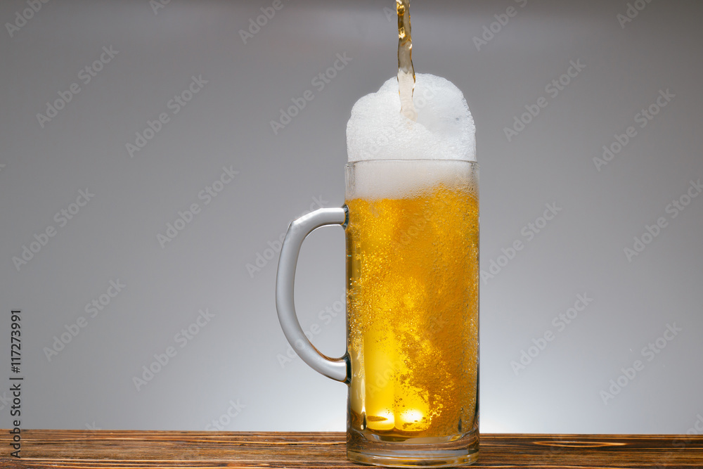 overflowing beer mug Stock Photo | Adobe Stock