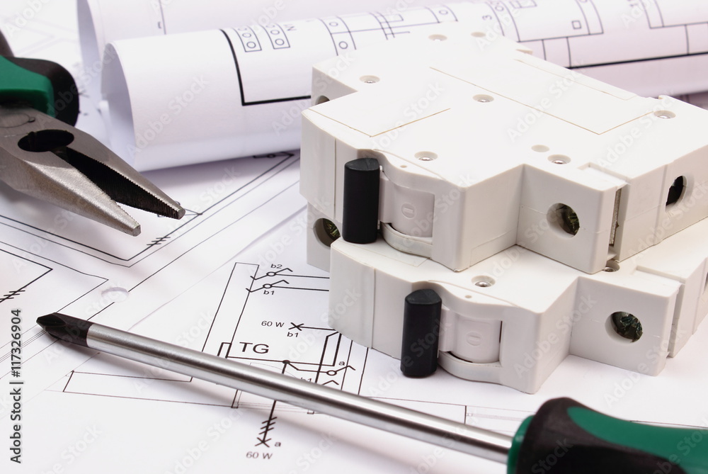 Work tools, electric fuse and rolls of diagrams on construction drawing ...