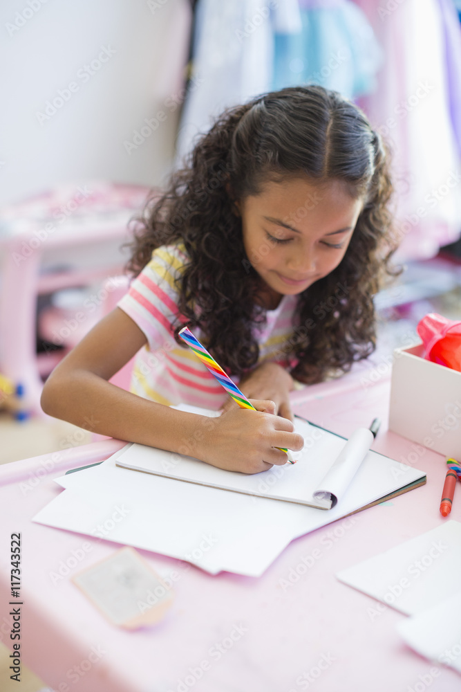 Foto de Girl drawing at desk do Stock | Adobe Stock