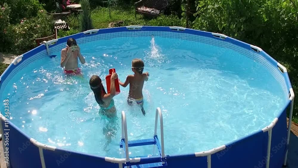 Weekend. Swimming pool. Children playing in the pool. Little girl ...
