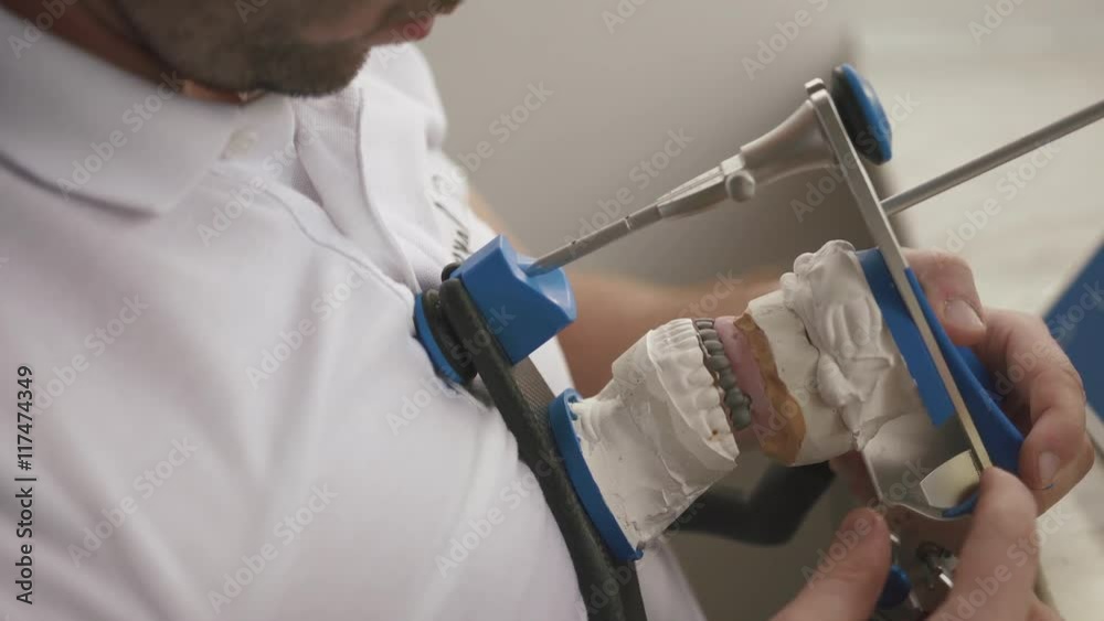 Dental prosthetic restoration. Denturist is trying occlusion while ...