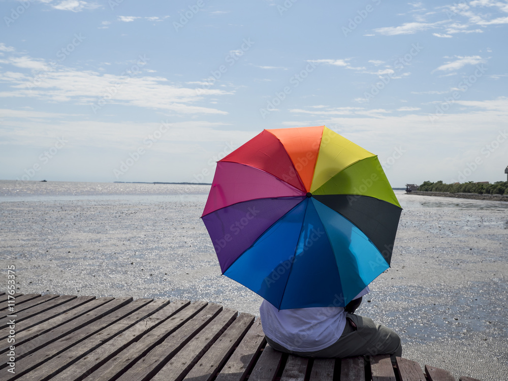 Single man sitting and hold colorful umbrella 1 Stock Photo | Adobe Stock