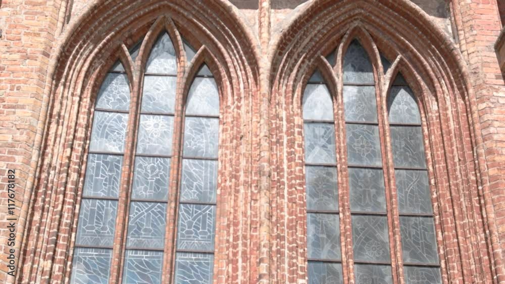 Building of red brick. Pattern on tall windows. Example of gothic ...