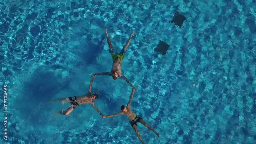 Men have fun swim in pool outdoors top view aerial. 3 young men boys ...