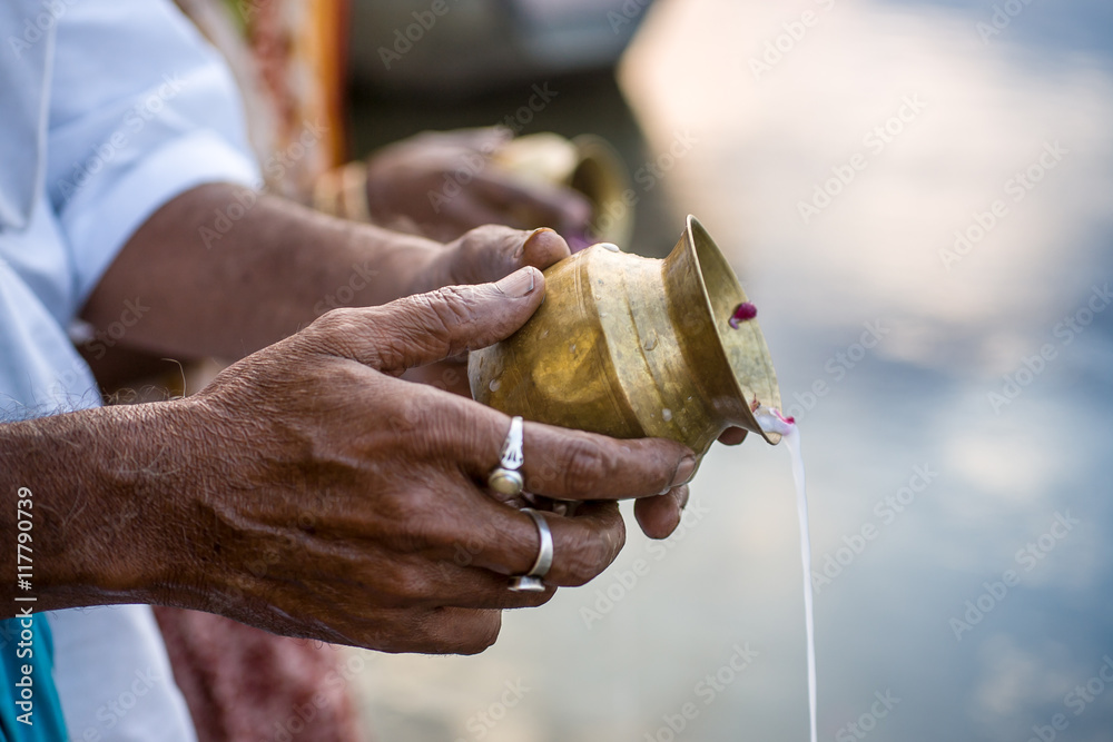 Hands pouring sacred water into a river during daily worship Stock ...