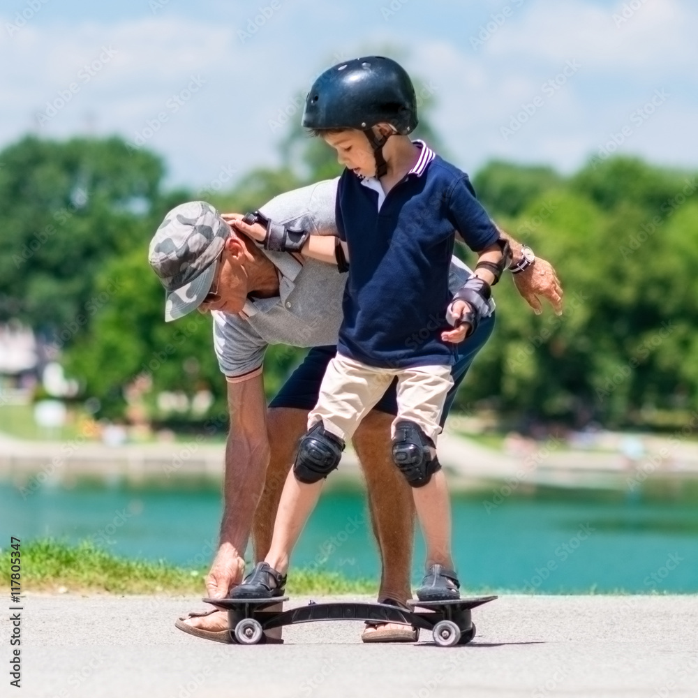 Learning how to ride a snakeboard by the lake Stock-Foto | Adobe Stock