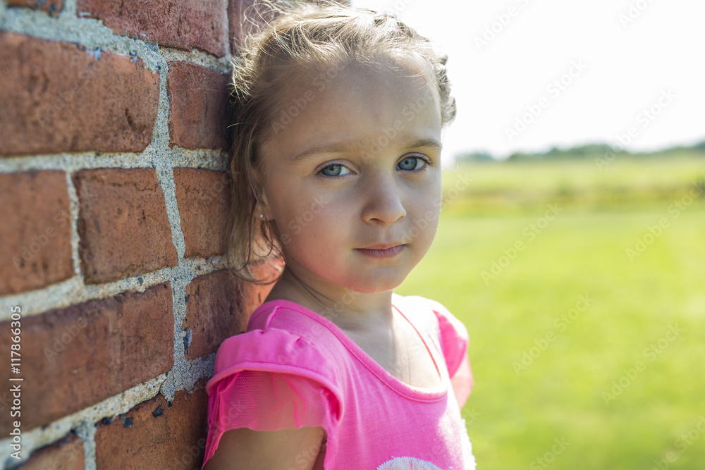 Worried little girl brick house Stock Photo | Adobe Stock