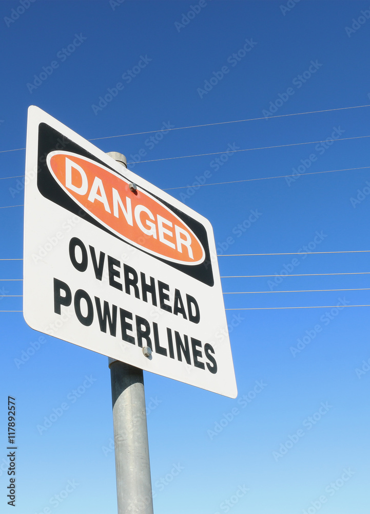 Danger, overhead powerlines warning sign, with visible power lin Stock ...