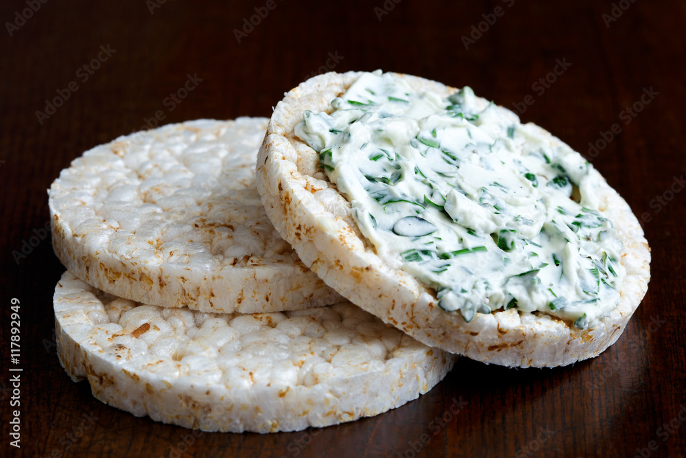 Pile of three puffed rice cakes isolated on dark wood. With chive and ...