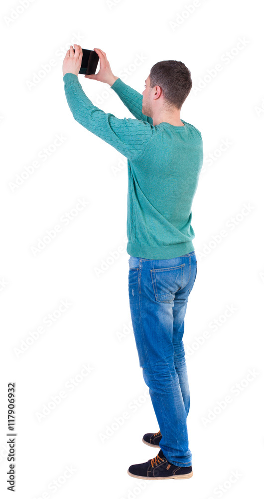 back view of standing business man photographing a phone or tablet ...