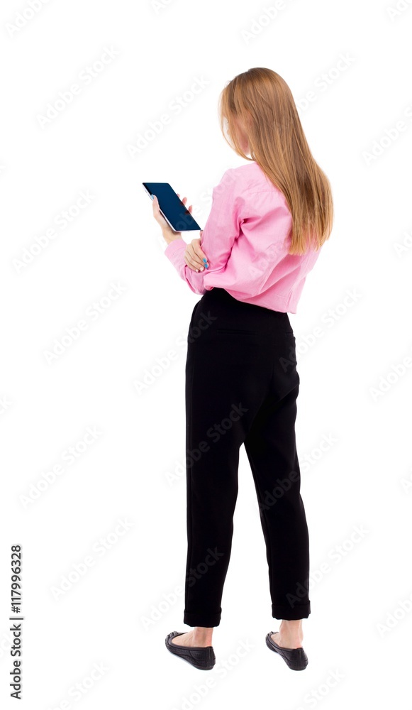 back view of standing young beautiful girl with tablet computer in the ...